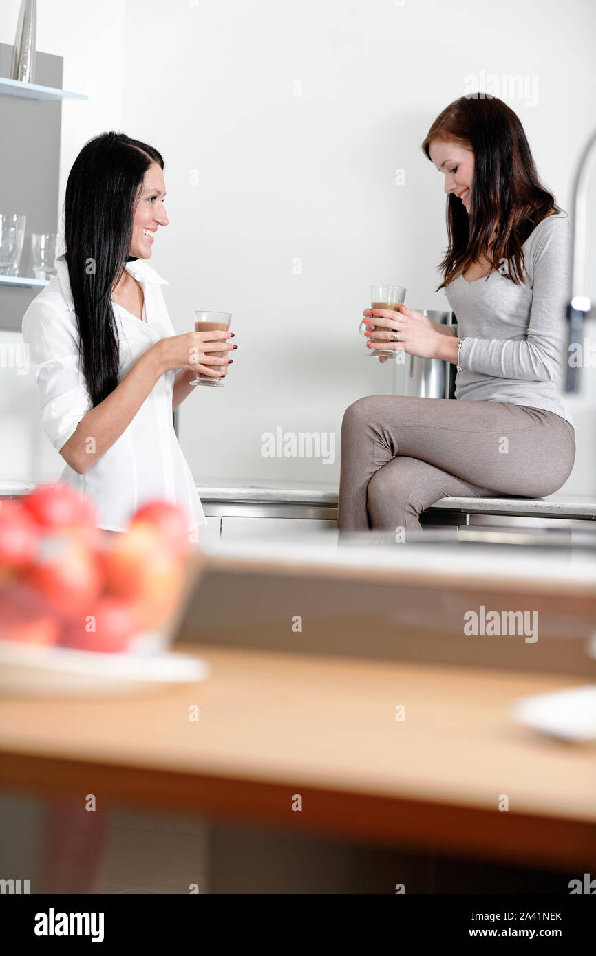 Two friends catching up over coffee in their kitchen Stock Photo - Alamy