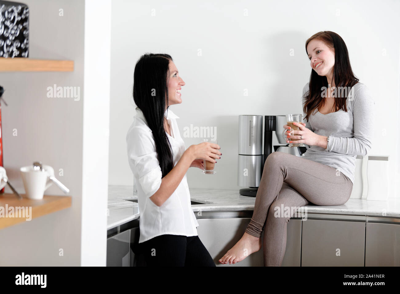 Two friends catching up over coffee in their kitchen Stock Photo - Alamy