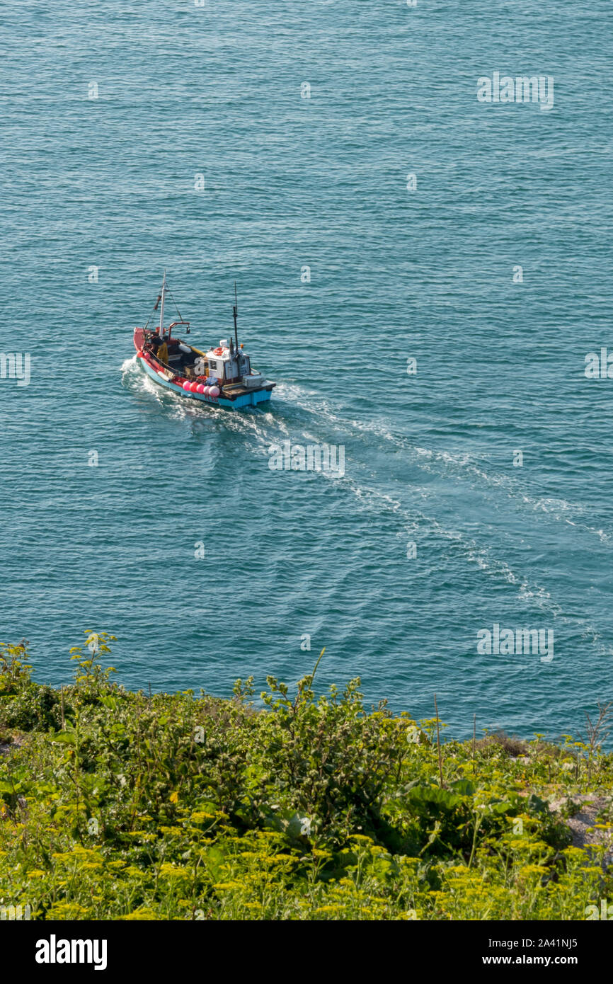A small inshore fishing boat or trawler of the coast at sea on the Isle ...