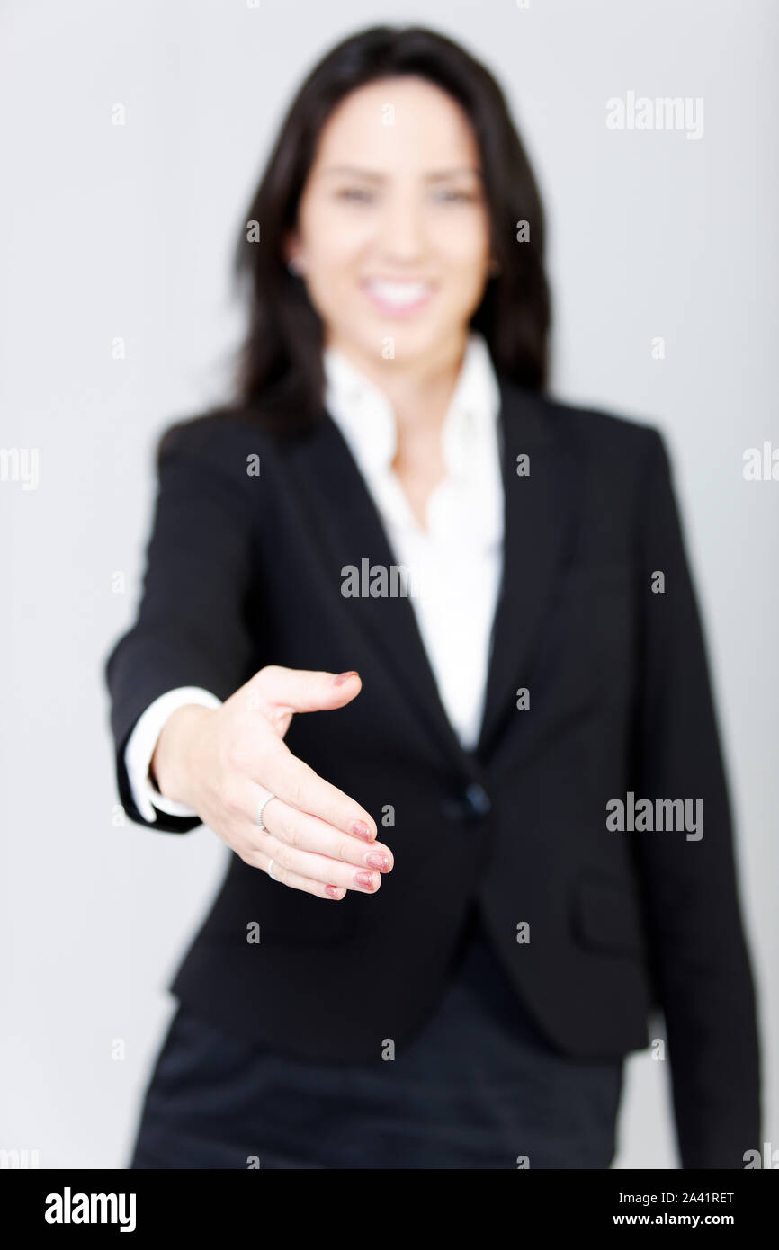 Professional business woman in a smart suit extending her hand out ...
