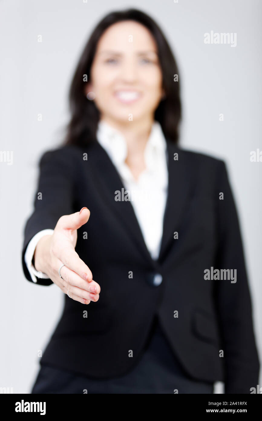 Professional business woman in a smart suit extending her hand out ...