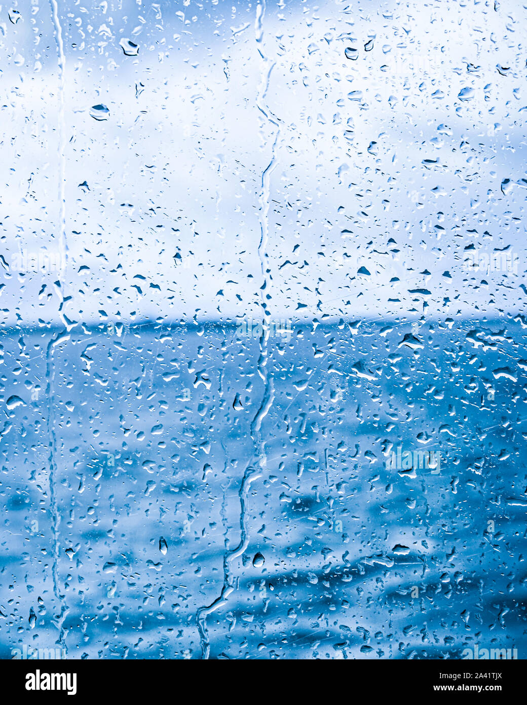 Water drops on glass against blue background Stock Photo - Alamy