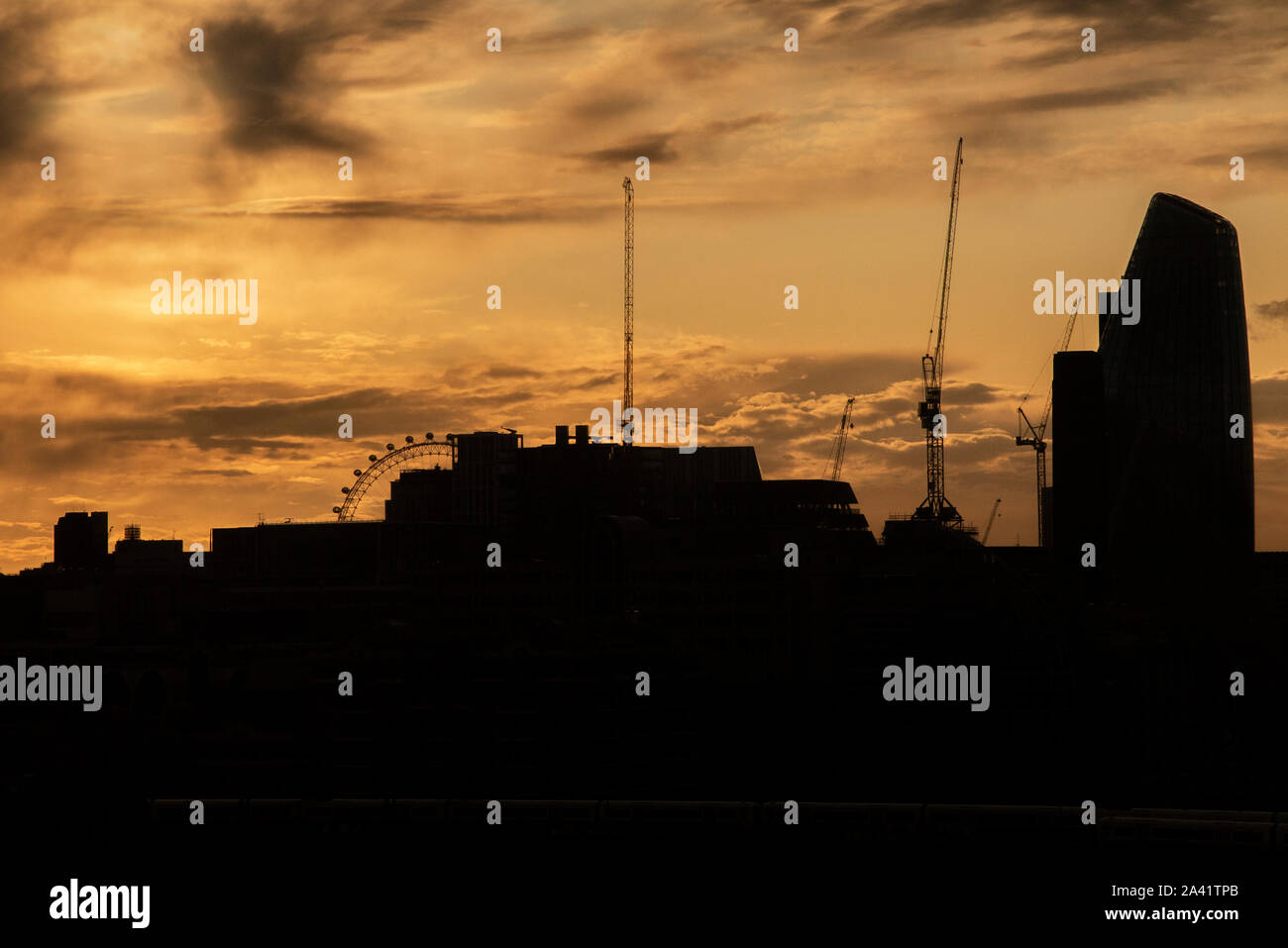 The Boomerang Building and the London Eye and cranes, silhouetted under ...