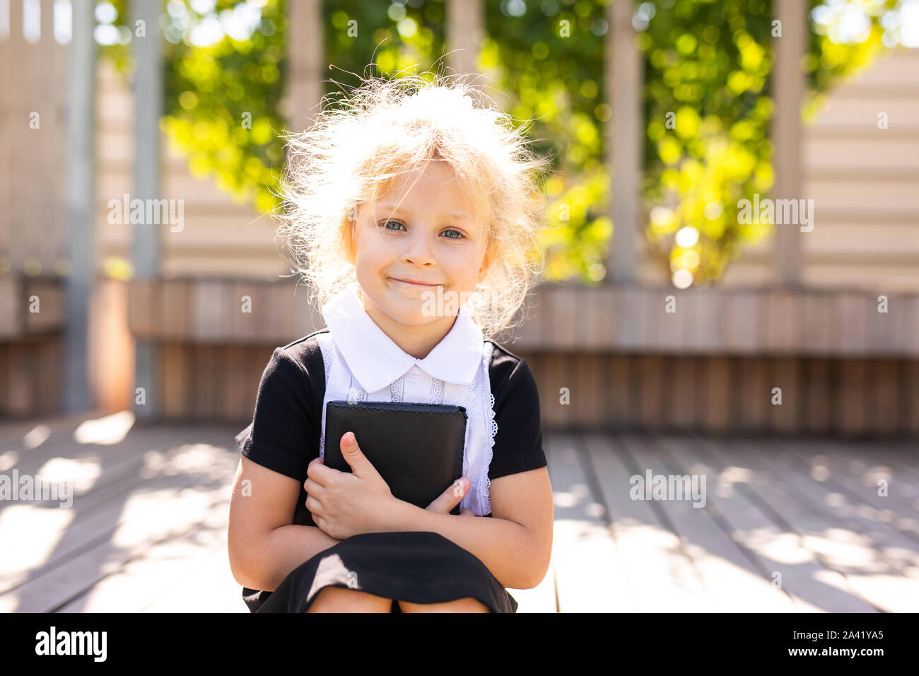 Back to school and happy time! Cute industrious child sitting outdoors ...