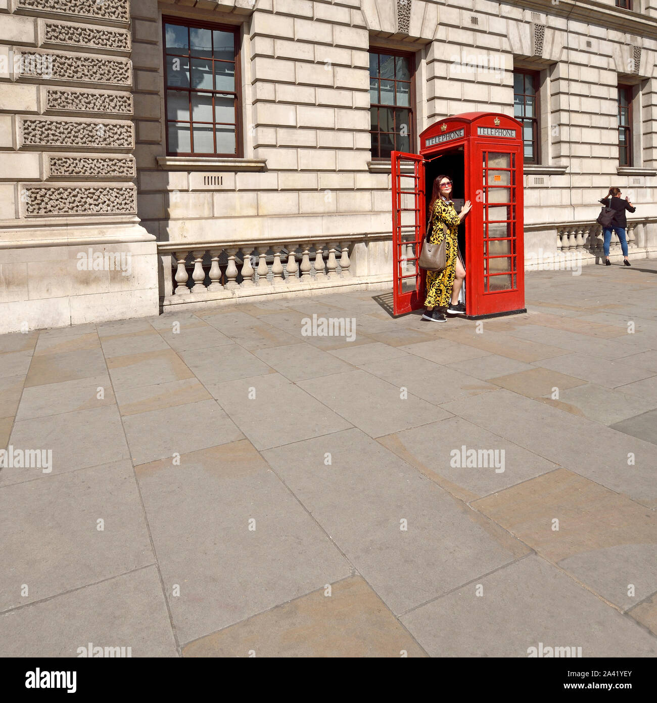 London, England, UK. Japanese woman posing for a photo by a traditional ...