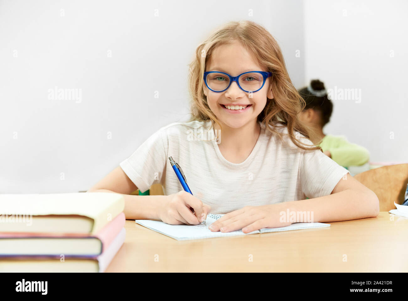 Happy female student learning during lesson at school. Beautiful girl ...