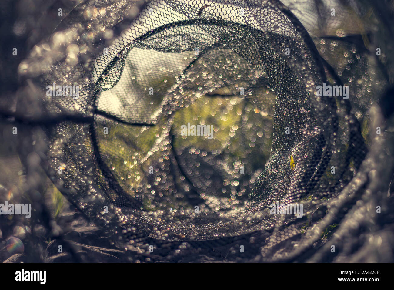 A wet fishing net photographed from the inside with a blurred ...