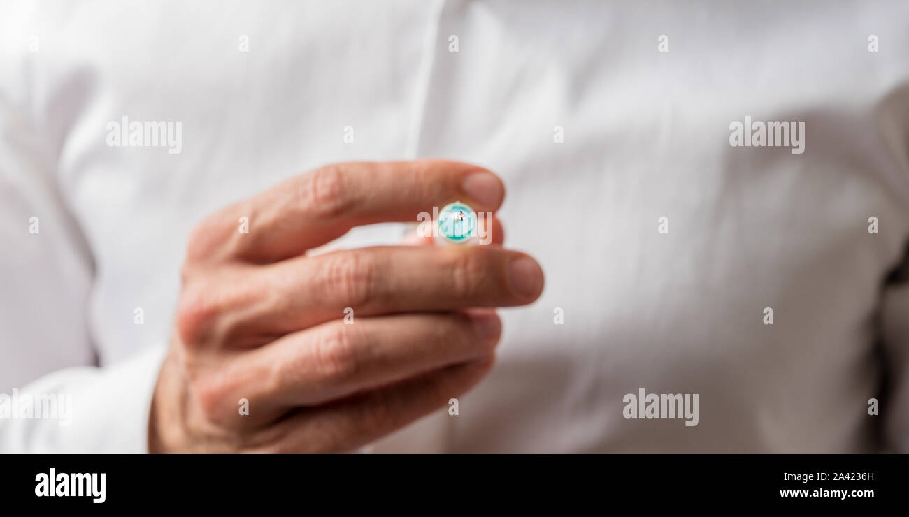 Closeup of medical doctor holding an injection with needle pointing ...