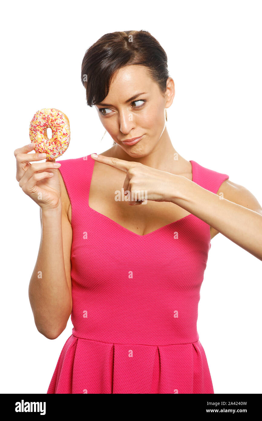 Young woman holding a doughnut looking guilty Stock Photo - Alamy