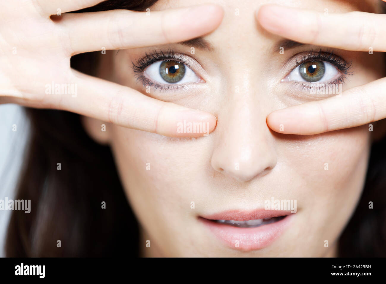 Young woman dancing and covering eyes with fingers Stock Photo - Alamy
