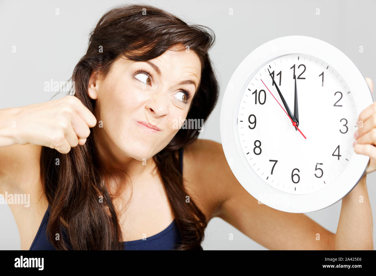 Woman with clock face looking concerned Stock Photo - Alamy
