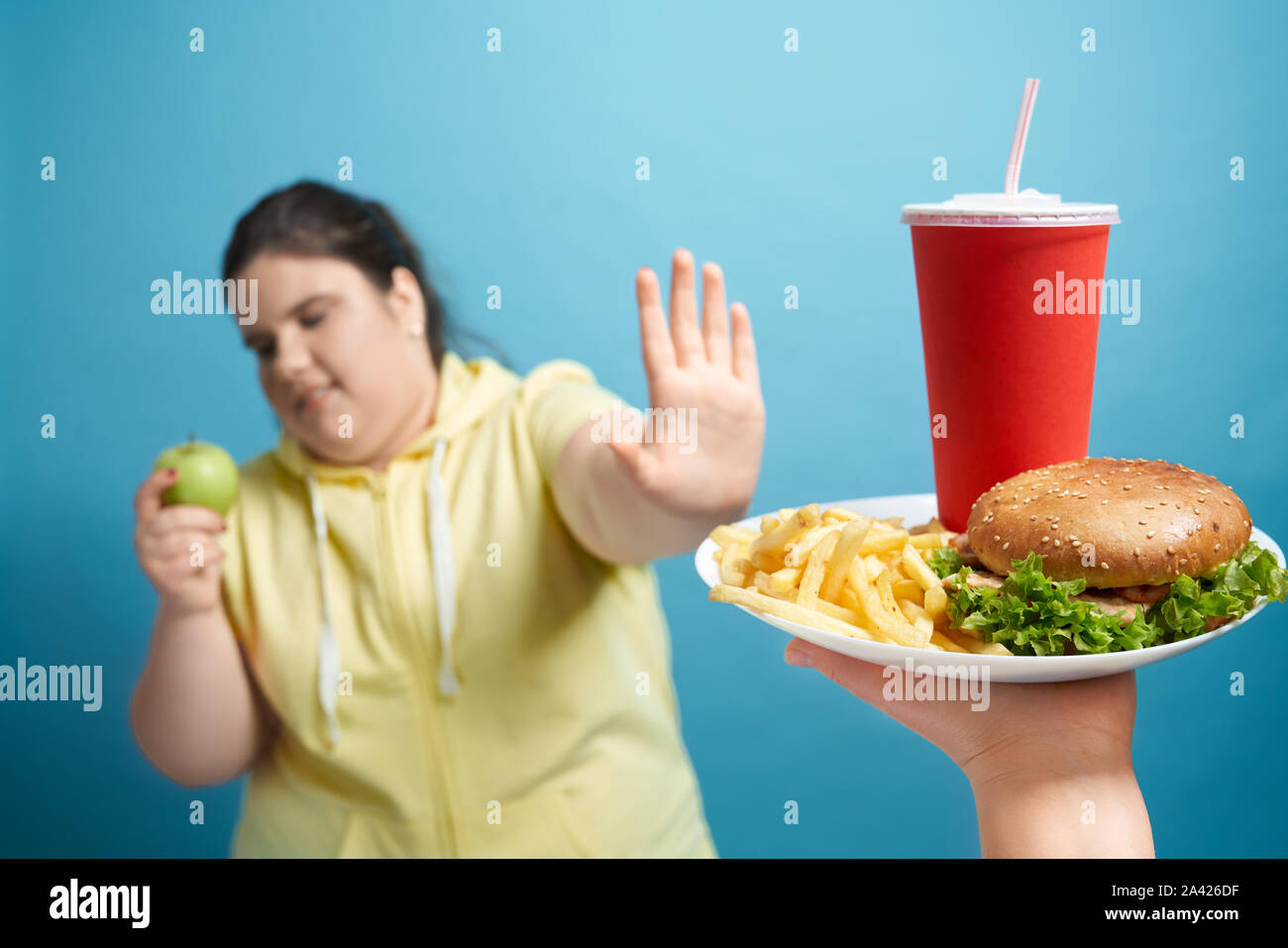 Portrait of chunky young lady in yellow sweater with closed eyes ...
