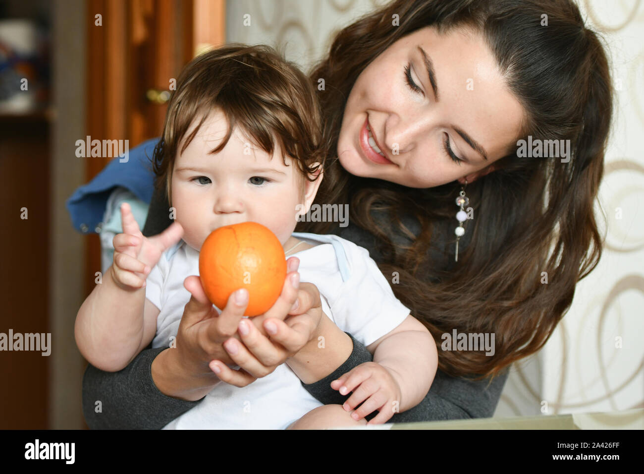 Mom gives an orange to a child. vitamins to the child. fruit for ...