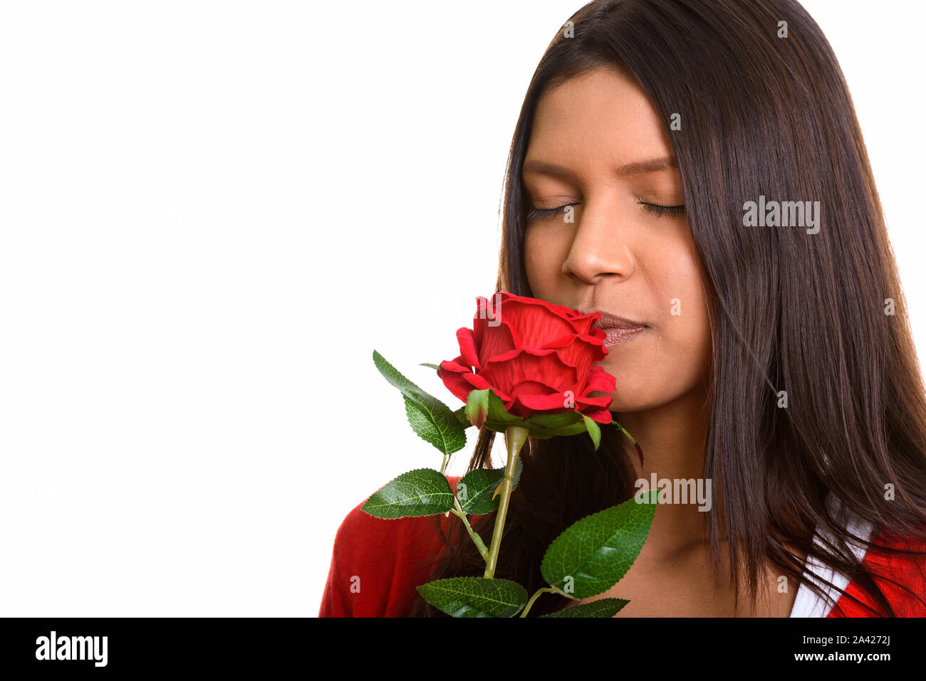 Studio shot of young beautiful Brazilian woman smelling red rose Stock ...