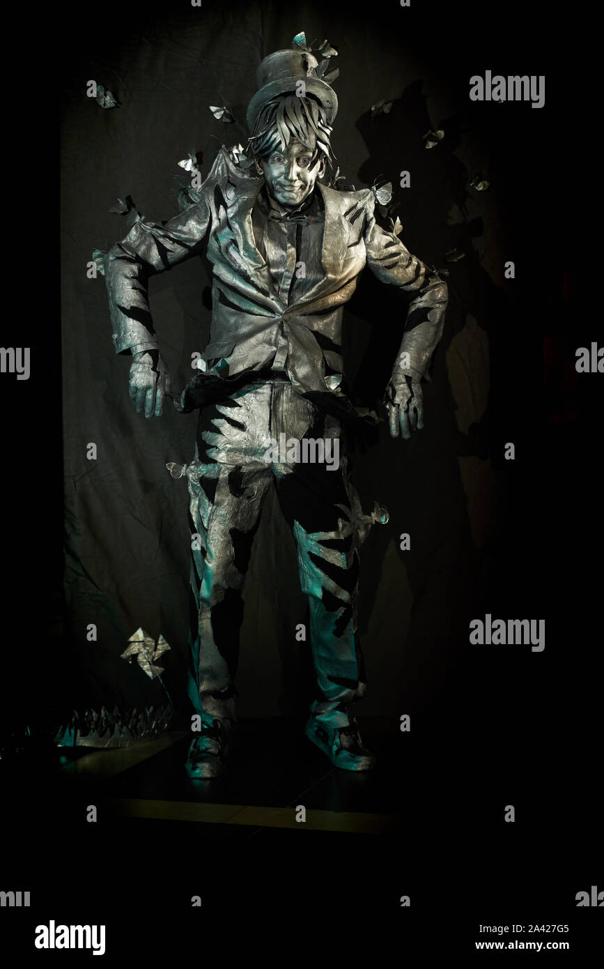 Full length portrait of pantomime artist, fully painted in grey and ...