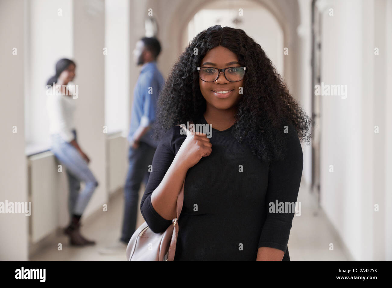 Portrait of african female college student with curly black hair in ...