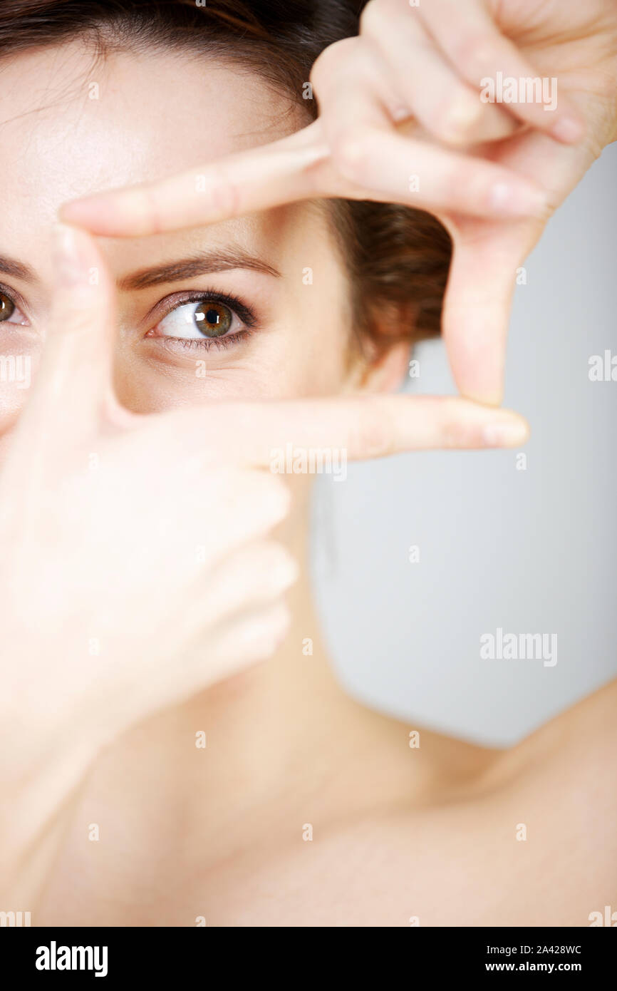 Woman peering though her fingers making a camera style shape Stock ...