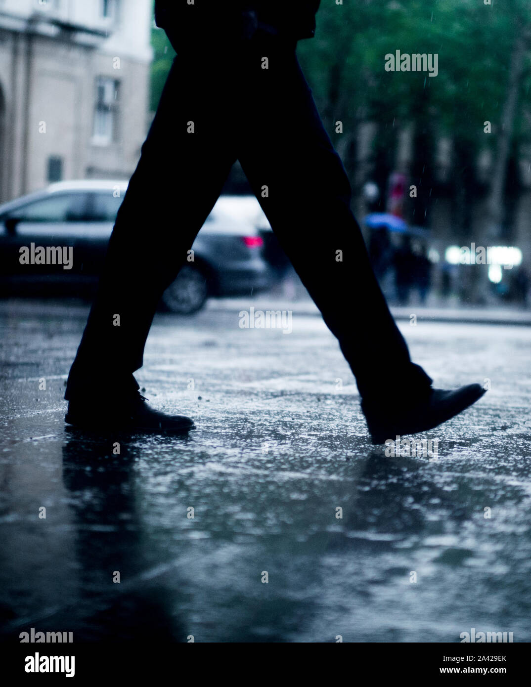 pedestrian walking on sidewalk on a rainy day Stock Photo - Alamy