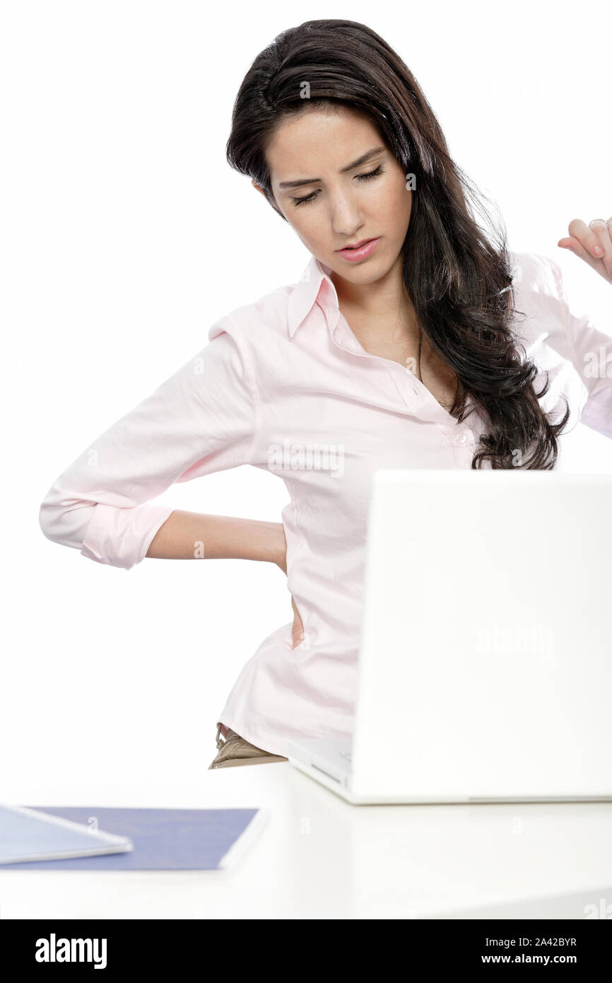 Beautiful young woman with back pain at her office desk Stock Photo - Alamy