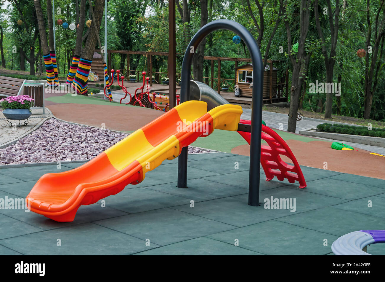 Childrens slide located on playground in the city park on a summer day ...
