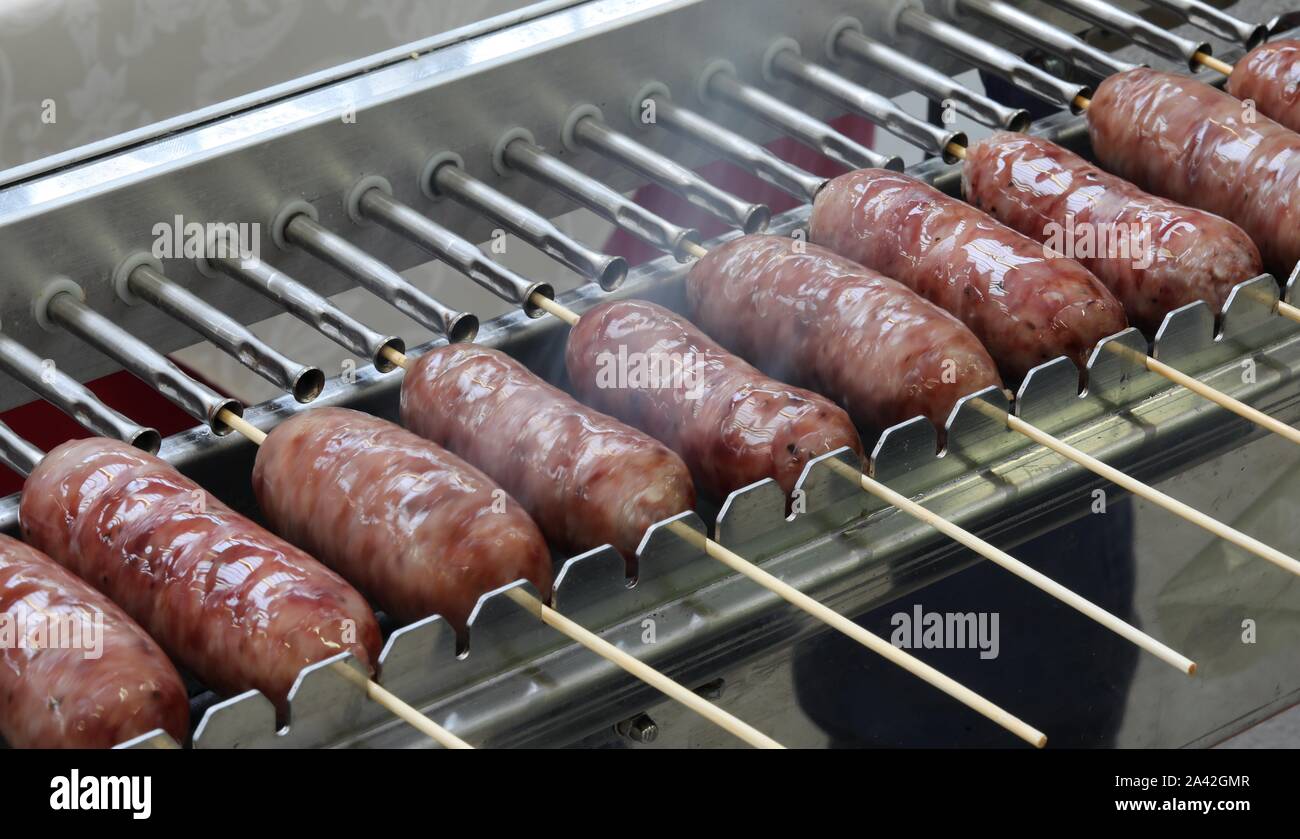 many rotating sausages on the spit in the rotisserie Stock Photo - Alamy