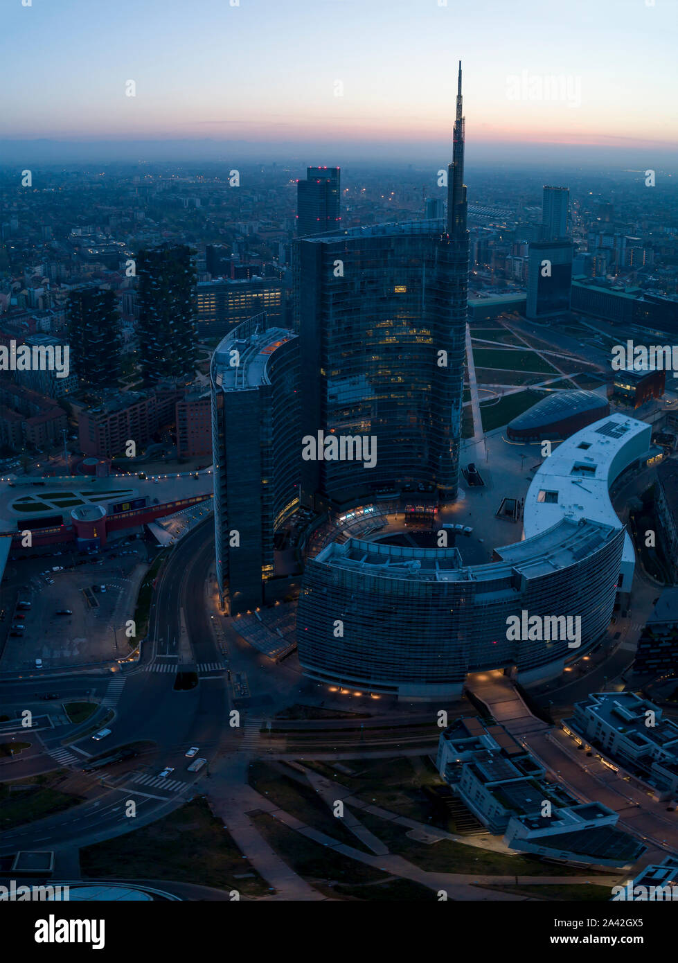 Aerial night view of Milan before sunrise. Flying over building and ...