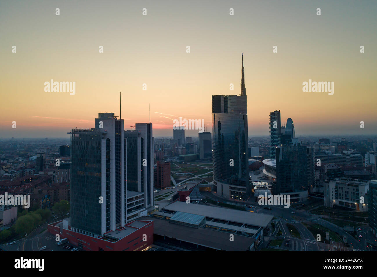 Aerial night view of Milan before sunrise. Flying over building and ...