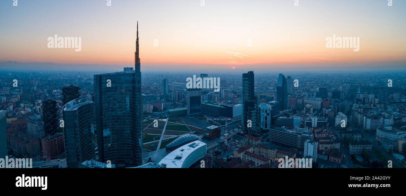 Aerial night view of Milan before sunrise. Flying over building and ...