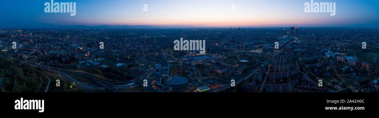 Aerial view of Milan skyline at dawn. Flying over building and ...