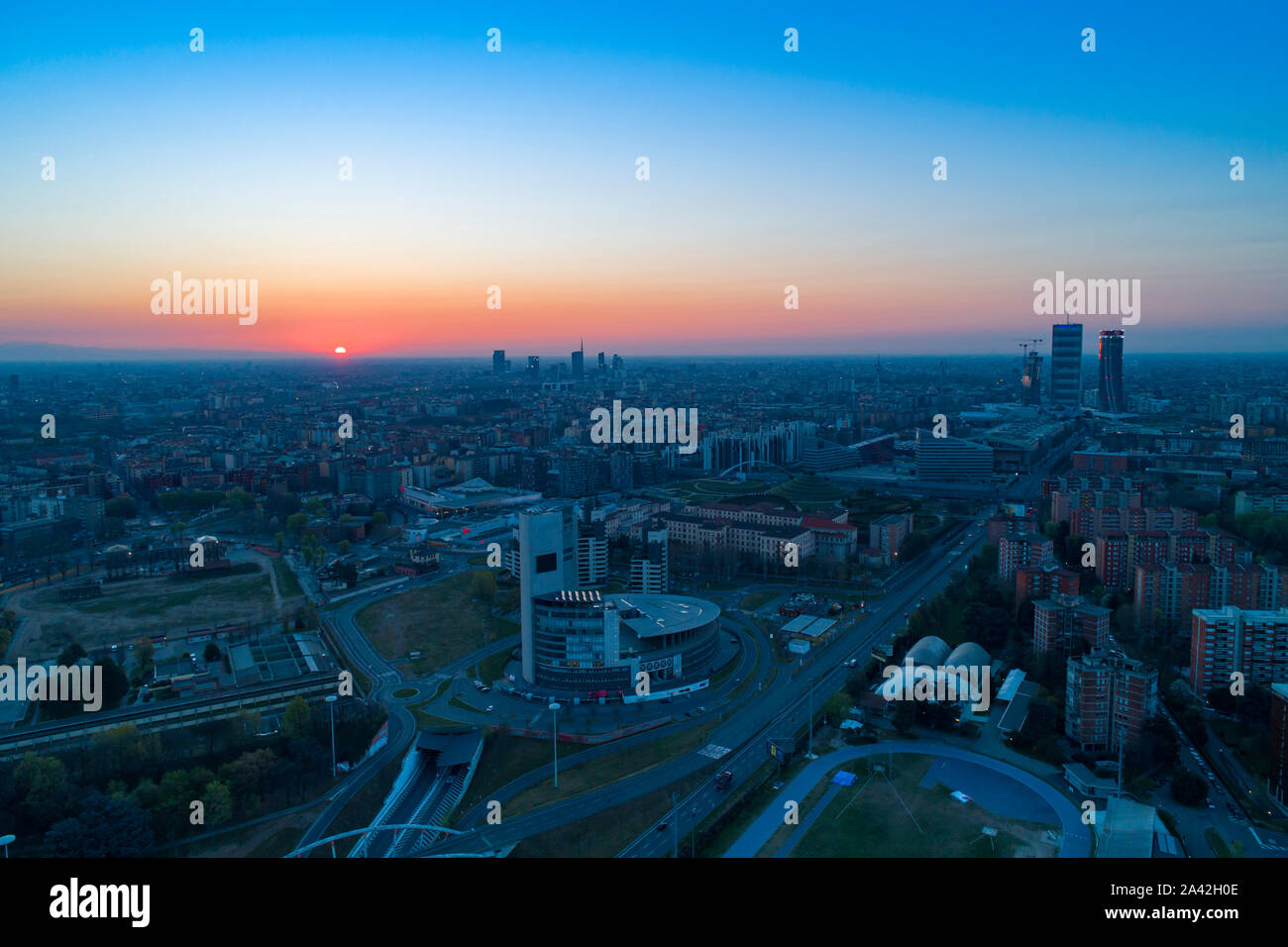 Aerial view of Milan skyline at dawn. Flying over building and ...