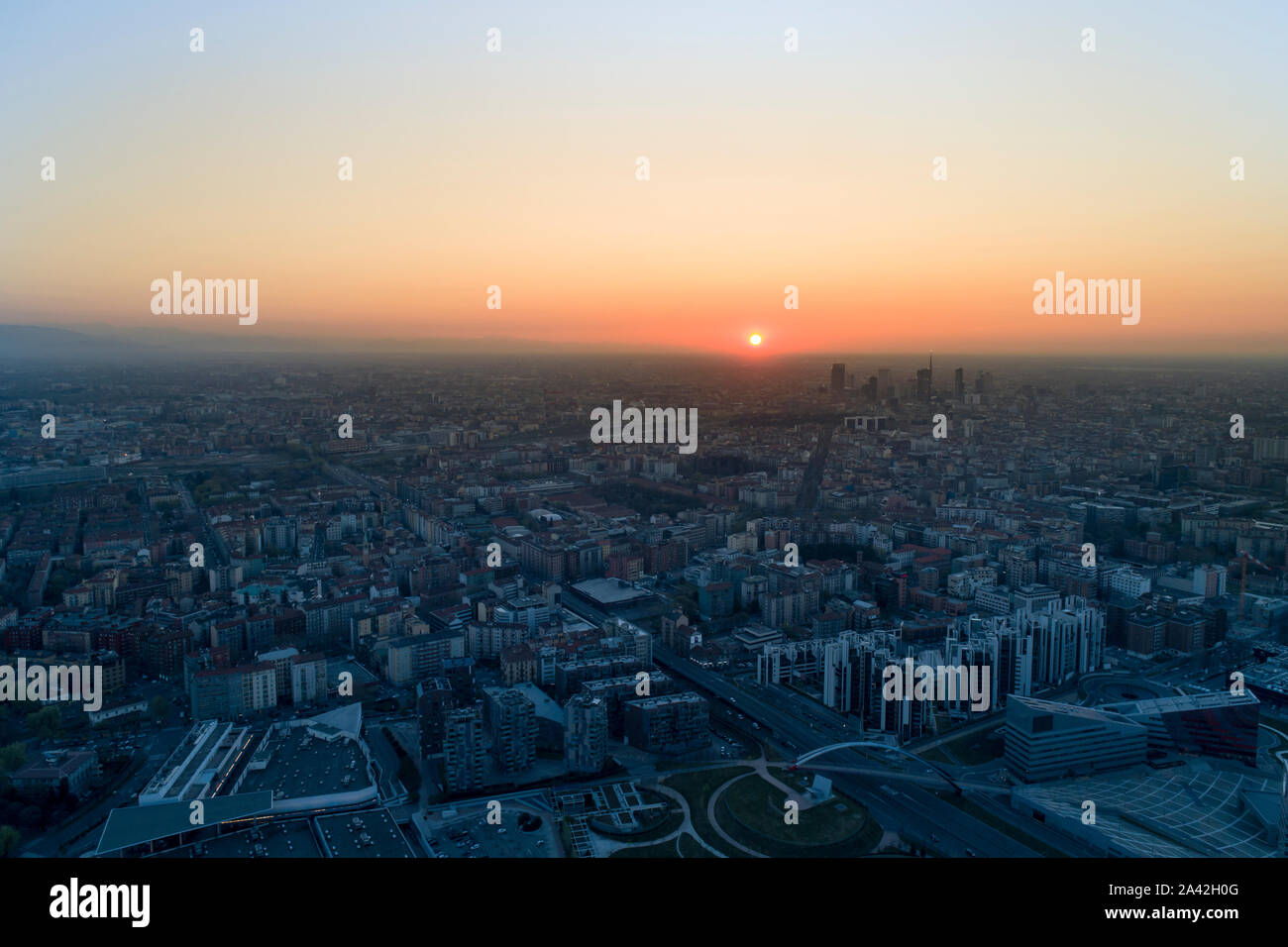 Aerial view of Milan skyline at dawn. Flying over building and ...