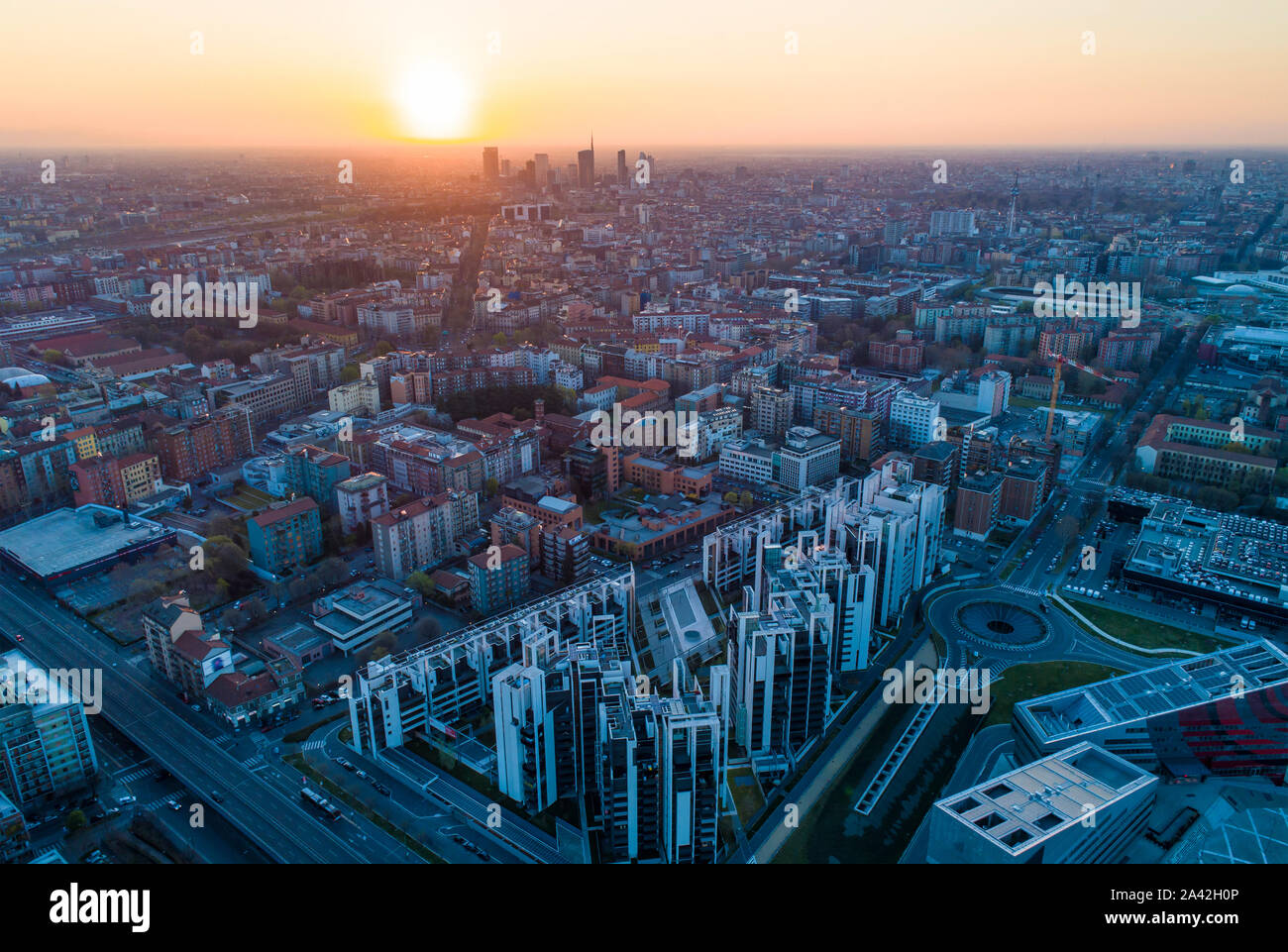 Aerial view of Milan skyline at dawn. Flying over building and ...