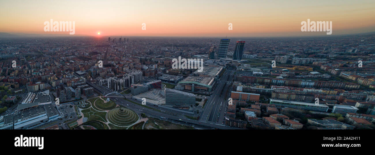 Aerial view of Milan skyline at dawn. Flying over building and ...