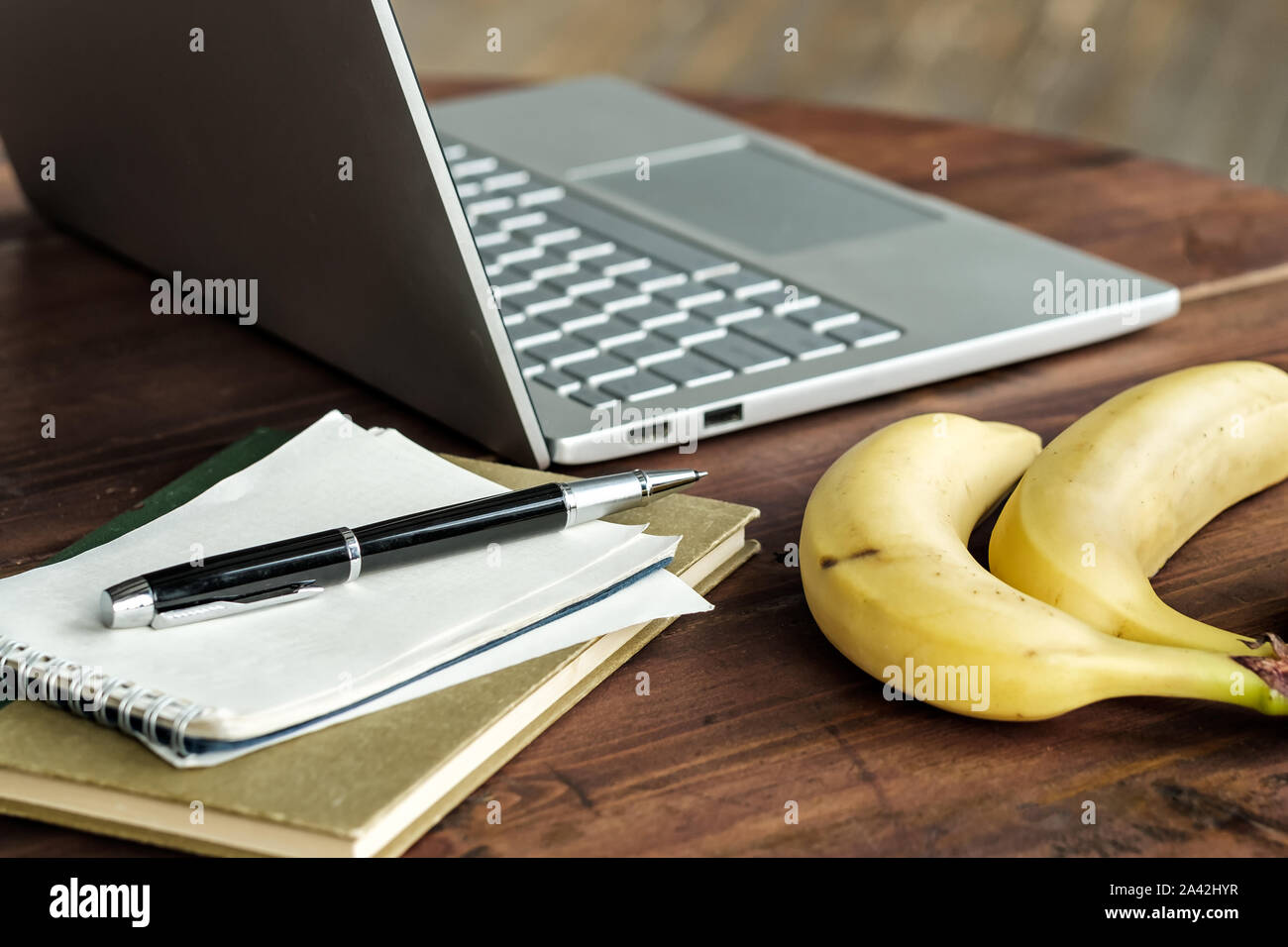 Workplace with modern laptop, notebook and banana Stock Photo - Alamy