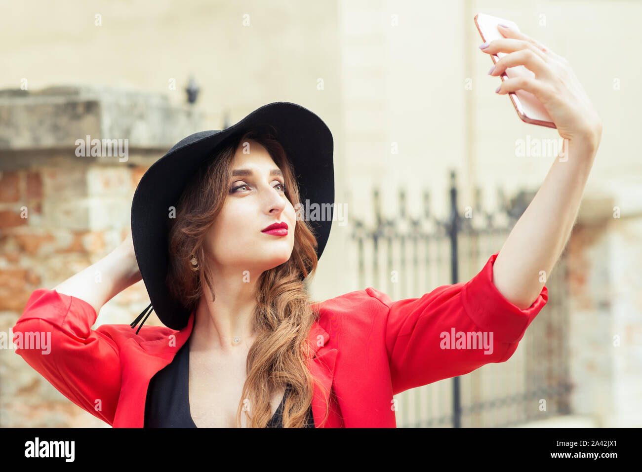 Close up portrait of a beautiful young woman is posing and makes selfie ...
