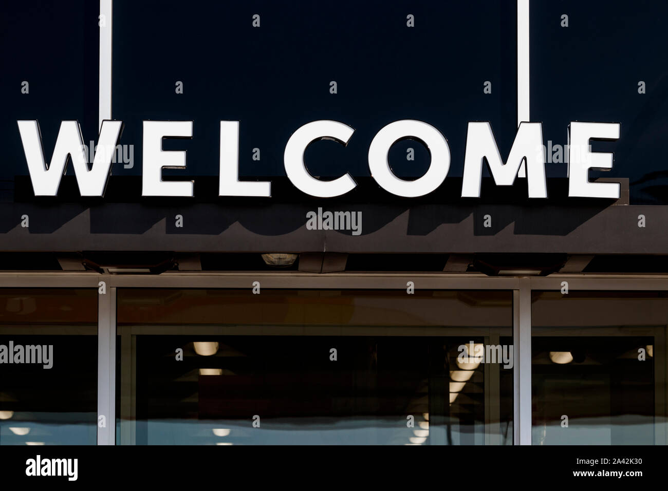 Welcome sign banner above business entrance Stock Photo - Alamy