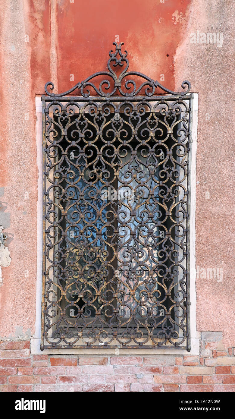 Ancient old window exterior with metal fence on faded house facade ...