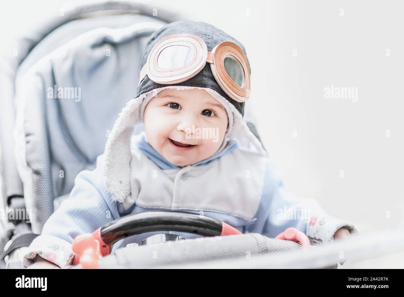 cute smiling baby in the cap of the pilot sitting with Helm in Baby ...