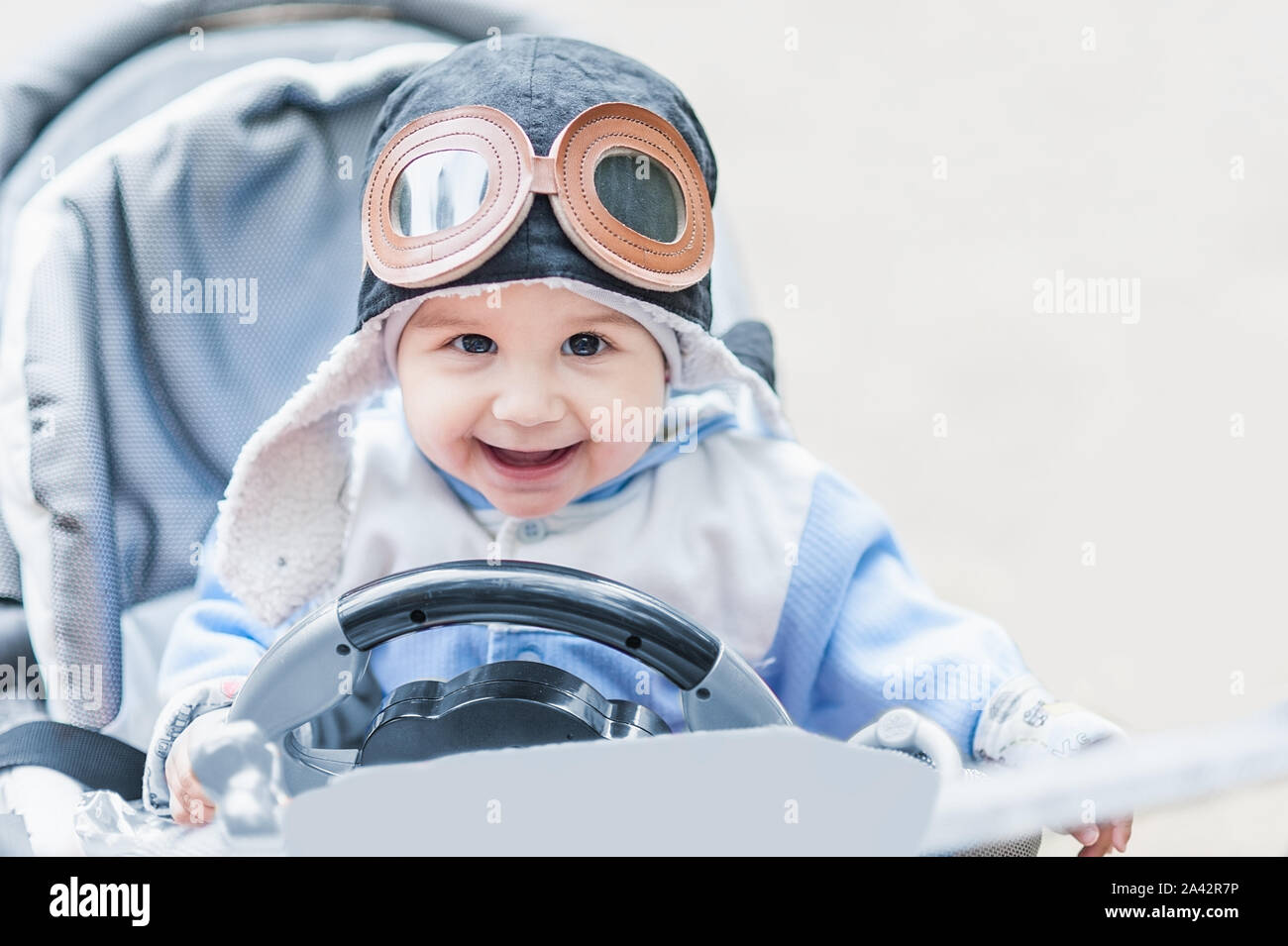 cute smiling baby in the cap of the pilot sitting with Helm in Baby ...