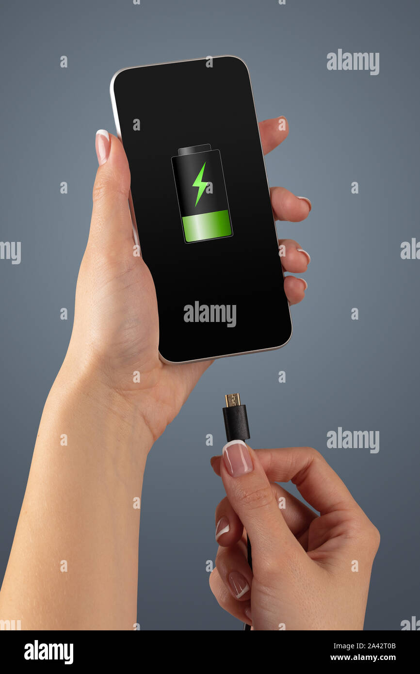Elegant hand charging cellphone with low battery Stock Photo - Alamy