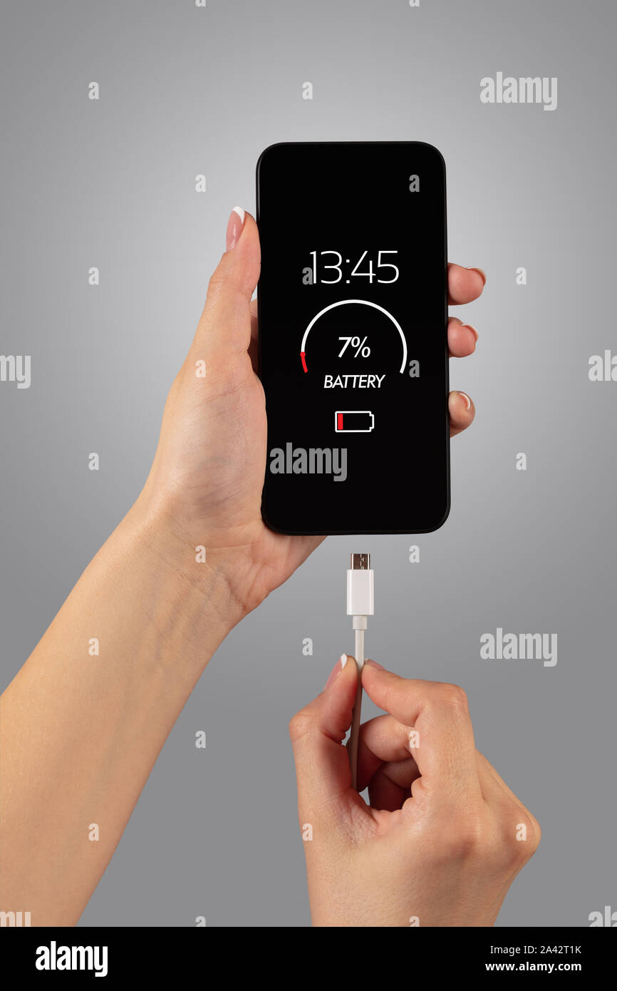 Elegant hand charging cellphone with low battery Stock Photo - Alamy