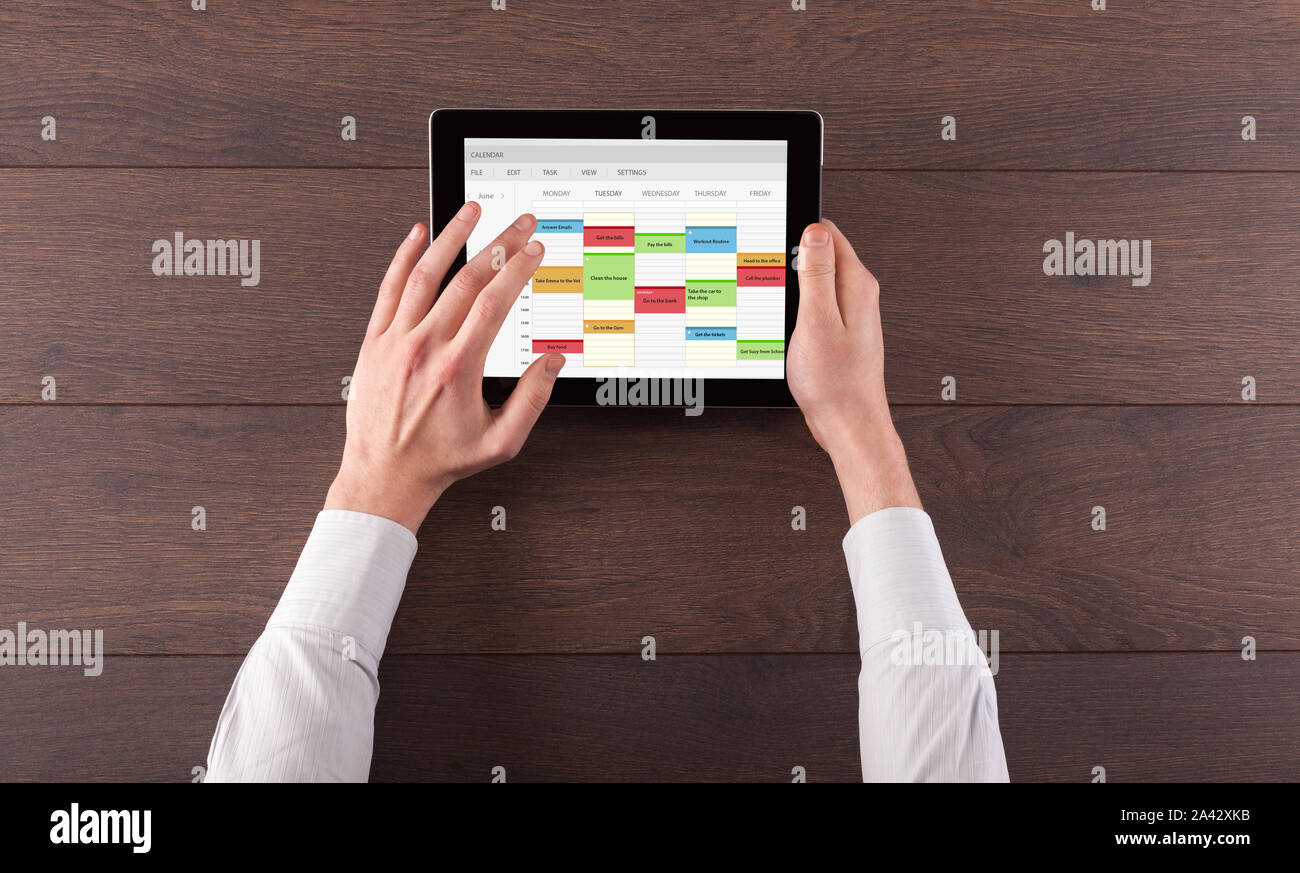 Hand holding tablet with timetable and calendar concept Stock Photo - Alamy