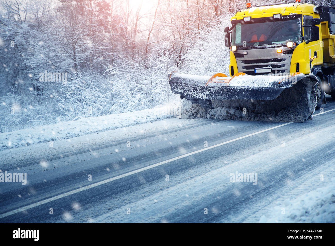Truck cleaning on winter road covered with snow Stock Photo - Alamy