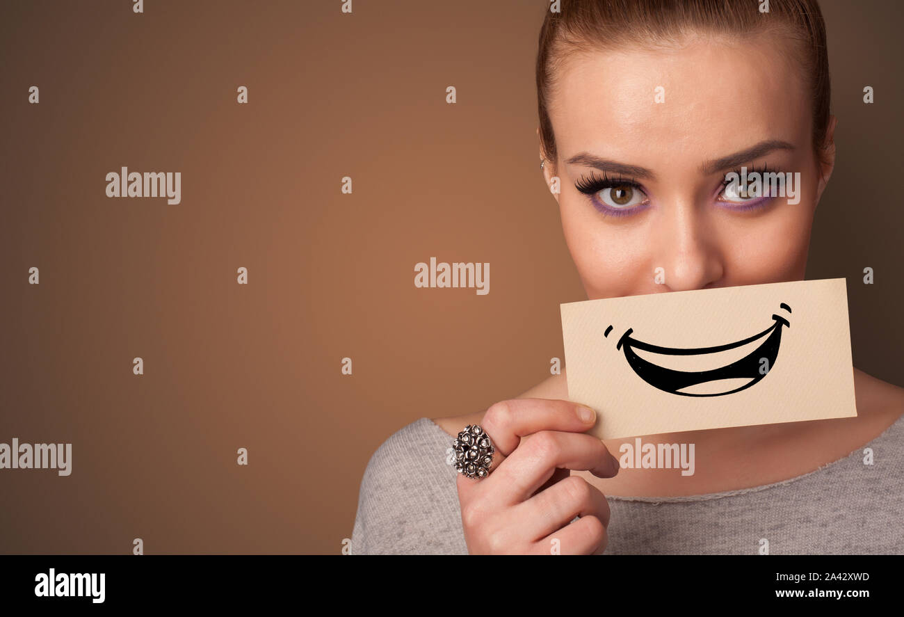 Person holding card in front of his mouth with ironic smile Stock Photo ...