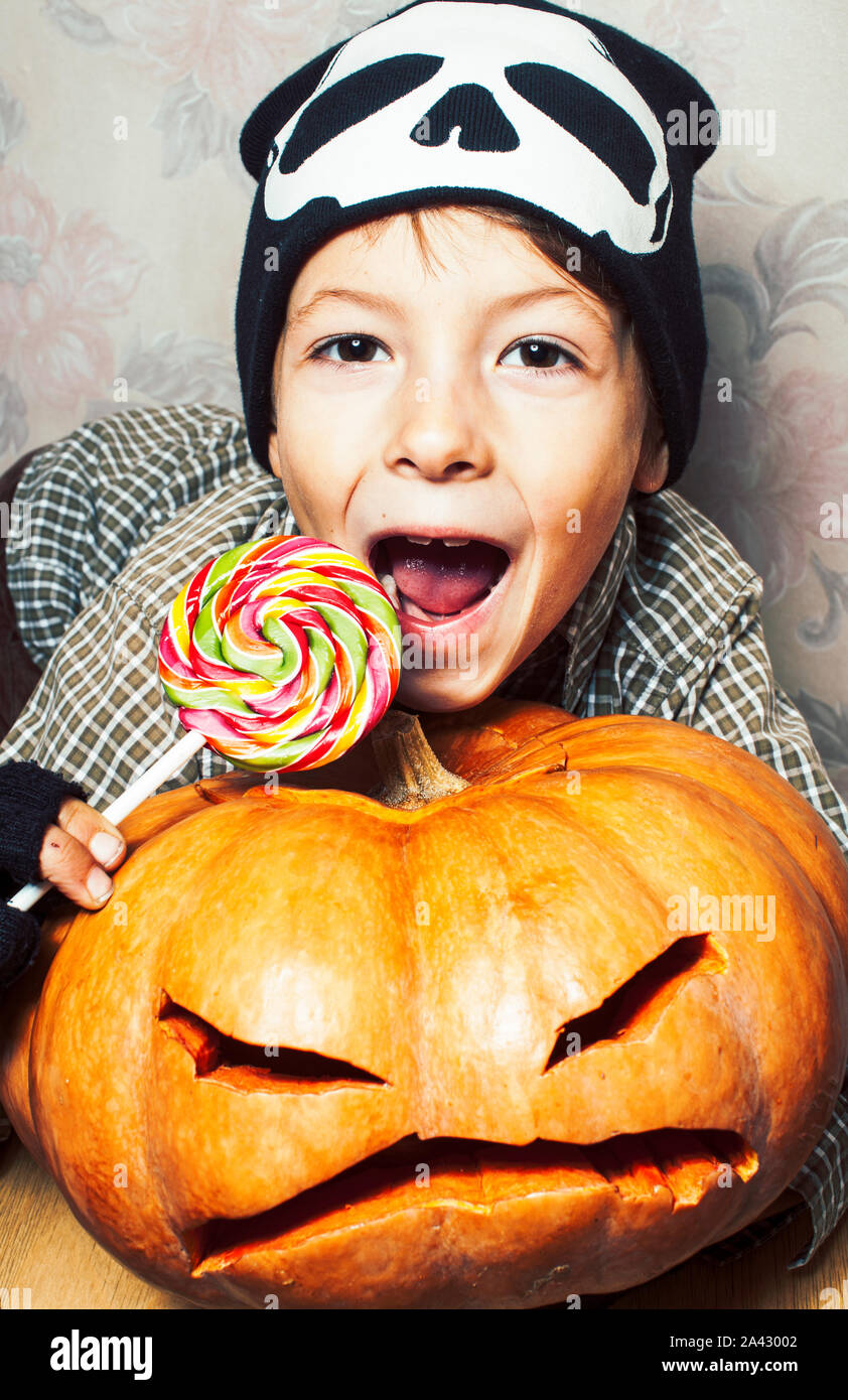 little cute boy in skeleton hat with pumpkin and candy at halloween ...