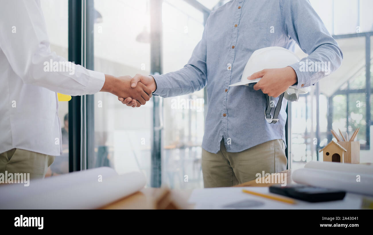 Two civil engineer or architect handshaking after have a good deal of ...