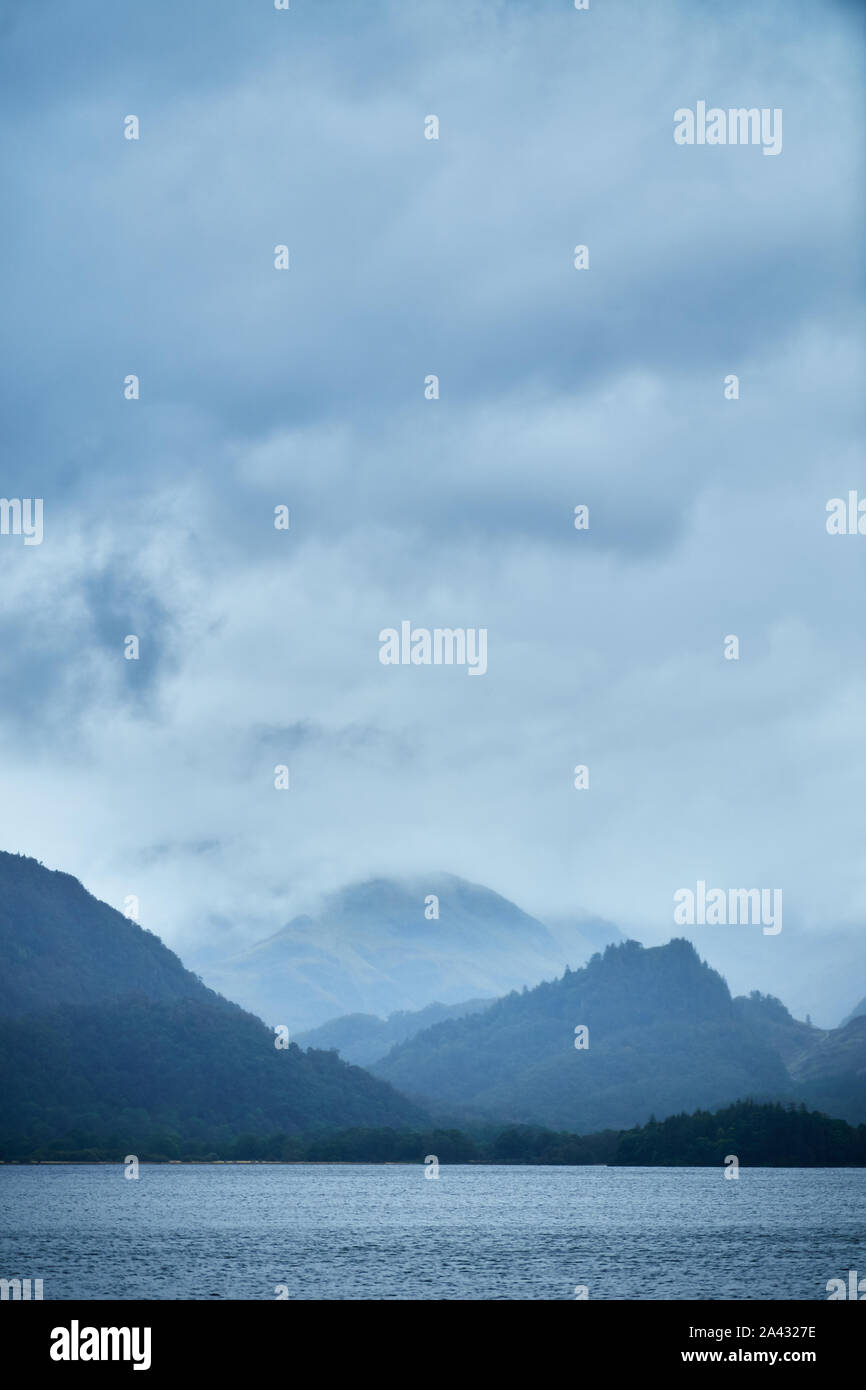 Outline of mountains at the shoreline on a cloudy, rainy day at Lake ...