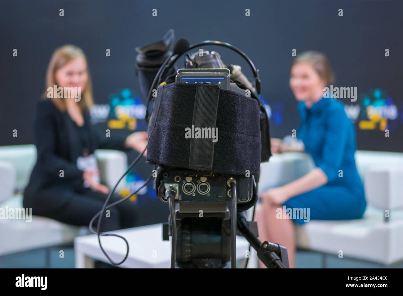 Television video camera recording interview in broadcast news studio ...