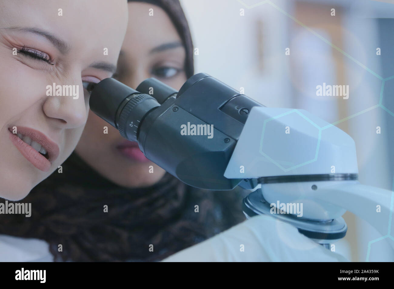 Two multiethnic young female scientists doing experiments in laboratory ...
