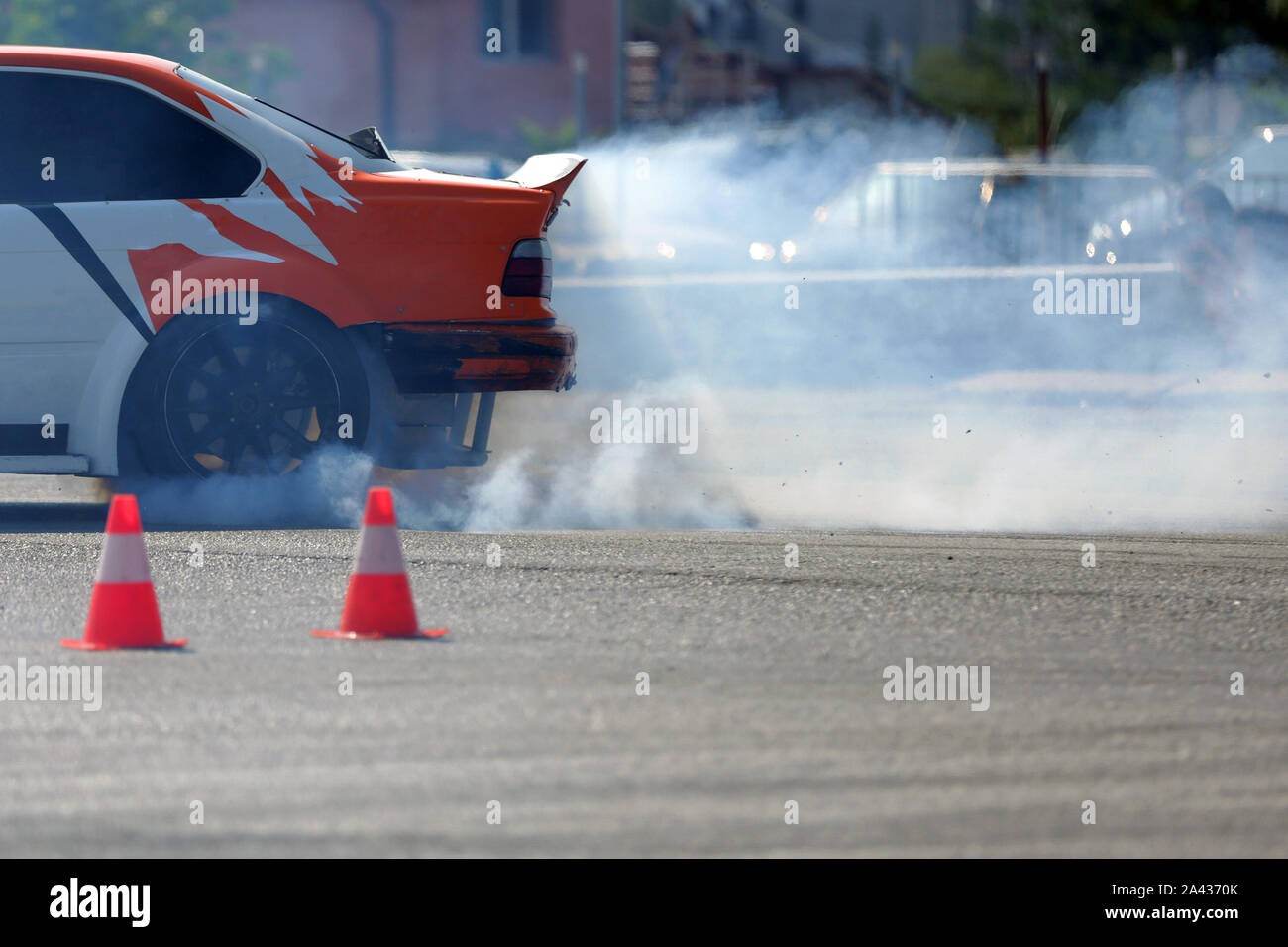 Sports car wheels drift and smoke on a track. Two cones in the ...